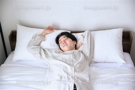 ベッドでくつろぐ日本人男性の写真素材 248801103 イメージマート