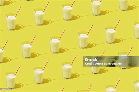 밝은 노란색 배경에 우유 한 잔과 빨간색과 흰색 종이 짚으로 만든 창조적 인 패턴 복고풍 미적 스타일 최소한의 창조적 인 개념