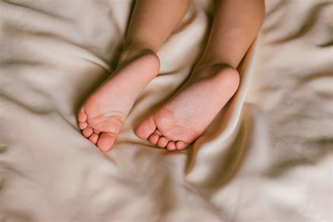 흰색 침대에 아이들의 발과 발 뒤꿈치 유아아기는 침대에서 자고 있습니다 아기를 위한 잠의 중요성 수면 모드 아기 3 Yo 개발에