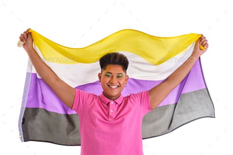 non binary asian person smiling in pink shirt holding non binary gender