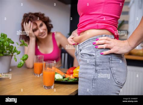 Woman Squeezes The Skin On Her Abdomen Between Her Fingers Assessing