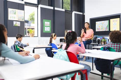 In School In A Classroom A Young Biracial Female Teacher Is