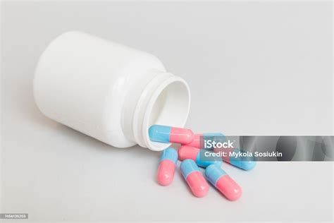 異なる薬や健康補助食品の丸薬は色付きの背景に医療と医療のトップビューの薬瓶から注がれた アセチルサリチル酸のストックフォトや画像を多数ご