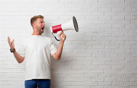 Premium Photo Handsome Blonde Man Shouting On A Megaphone