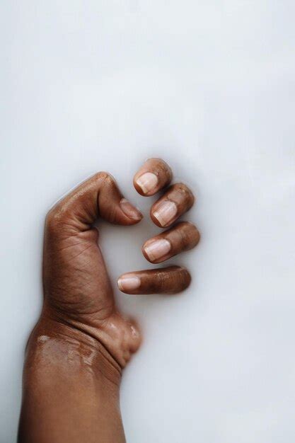 Premium Photo Dark Skin Hand In The Milky Smooth Water Substance