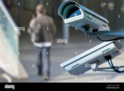 Security CCTV Camera Or Surveillance System With Man On Blurry Background Stock Photo Alamy
