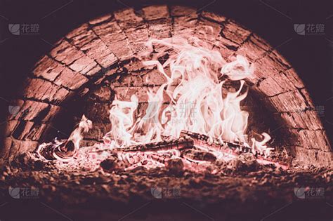 黑暗的背景。烤箱里用火烹饪的概念。关闭了。烤箱着火了。披萨在煤块里。伴侣的颜色