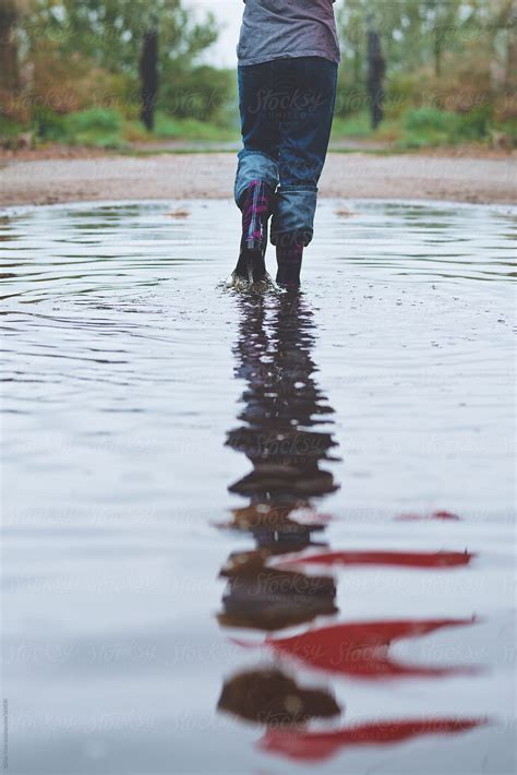 Girl Walking Through Puddle With Umbrella By Stocksy Contributor