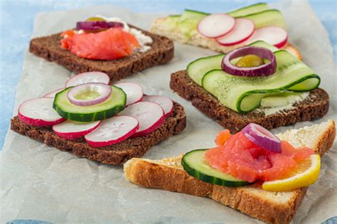 전채 다른 토핑 샌드위치를 엽니 다 파란색 배경에 종이에 연어와 야채 전통 이탈리아 또는 스칸디나비아 간식 건강한 식생활 닫기 텍스트에 대한 공간을 복사 Smorrebrod