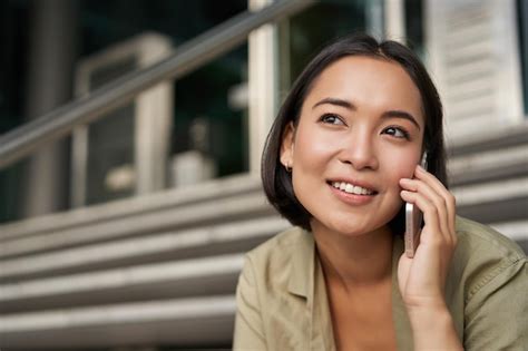 Premium Photo Portrait Of Asian Girl Smiles While Talks On Mobile
