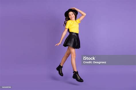 라일락 배경에 고립 된 멋진 낙관적 인 갈색 머리 머리 소녀 점프 착용 모자 티셔츠 스커트 신발의 풀 사이즈 프로필 사진 T