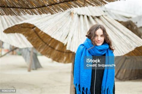 아름 다운 영의 초상화와 백그라운드에서 리드 우산 검은 코트와 추운 날씨에 야외에서 파란 스카프에 귀여운 여자 가리기에 대한 스톡 사진 및 기타 이미지 Istock