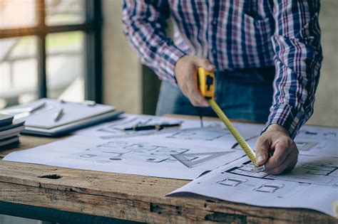 건설 현장의 청사진에서 건축가를 스케치하는 프로젝트에서 일하는 한 남자의 클로즈업 건축가 책상 건설 프로젝트 배너의 엔지니어 개념 건축가 장비를 사용한 도면 계획 마무리