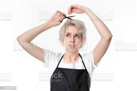 흰색 티와 검은 앞치마 에 예쁜 젊은 미용사 자신 의심의 감정을 표현 하는 머리를 절단 웰빙 및 뷰티 산업과 전문 경력 T 셔츠에 대한 스톡 사진 및 기타 이미지 Istock