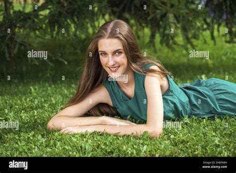 Close Up Portrait Of A Young Girl Lying On Green Grass Summer Park