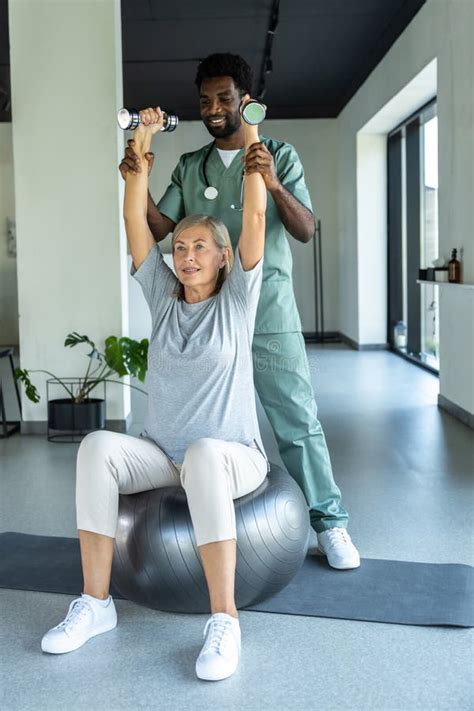 Male Physiotherapist Working With Patient In Clinic Using Physical