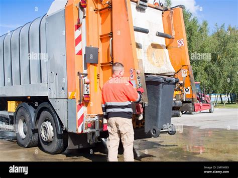 worker of urban municipal recycling garbage collector truck loading