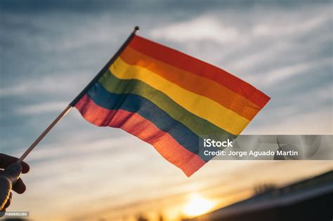 알아볼 수 없는 사람의 손이 해질녘 하늘에 무지개색 깃발을 들고 있다 Lgtbiq 컨셉 30 34세에 대한 스톡 사진 및 기타