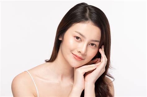 美しいアジアの若い女性は清潔で新鮮な肌の幸せと肯定的な感情的で陽気な笑顔を持つ美しいアジアの若い女性灰色の背景に隔離美容と化粧品のコンセプト