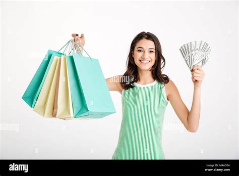 Portrait Of A Satisfied Girl In Dress Holding Shopping Bags And Showing