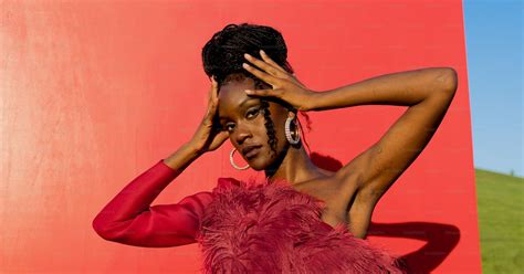 빨간 깃털 드레스를 입은 여자가 붉은 벽 앞에서 포즈를 취하고 있다 사진 Unsplash의 흑인 여자 이미지