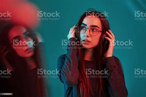 유리를 사용 하 여 Nce 반사 효과 스튜디오는 네온 빛실내 촬영 아름다운 어린 소녀의 초상화 갈색 머리에 대한 스톡 사진 및