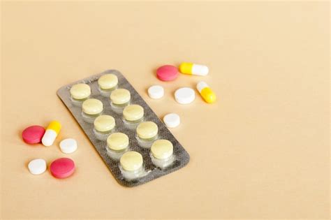 Paquete de blister con vitamina sobre fondo de color píldoras de