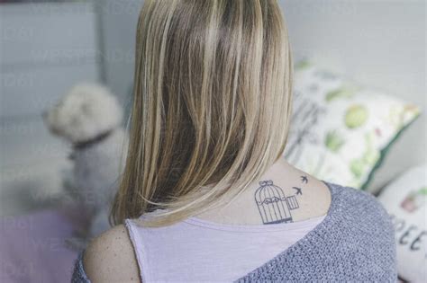 Back View Of Blond Woman With Tattoo On Her Neck Stock Photo