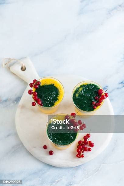 신선한 딸기와 안경에 두 색된 신선한 스무디 오렌지 바나나 주스 Spirulina 파우더입니다 아침 식사를 해독 건강 한 식습관