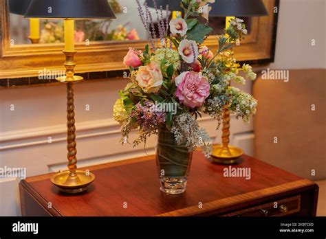 Flower Boquet On A Table With Two Shaded Lamps Stock Photo Alamy