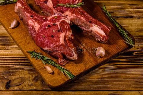 Raw Ribeye Steak Spices Rosemary And Garlic On Cutting Board Stock