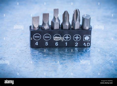 Set Of Stainless Screwdriver Bits On Metallic Background Construction