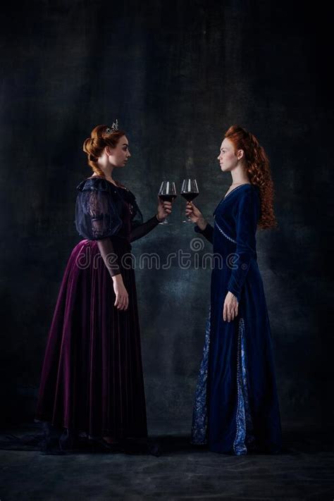 Portrait Of Two Beautiful Women In Image Of Queens Standing Face To