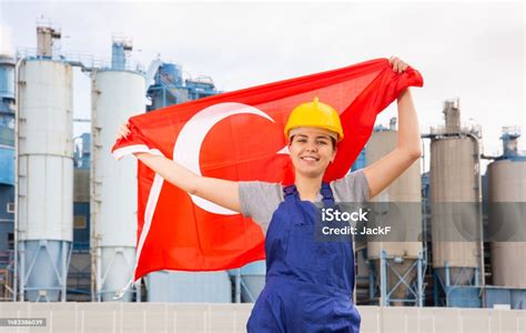헬멧을 쓴 젊은 여성 엔지니어가 화학 공장의 큰 탱크 앞에 서서 터키의 국기를 흔들고 있다 20 24세에 대한 스톡 사진 및 기타 이미지 20 24세 가솔린 강철