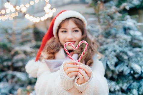 Focus On Heart Shape Made Of Candy Canes By Young Smiling Woman In