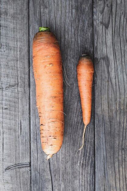 Premium Photo Two Carrots On Wooden Table Big Vs Small Self Esteem