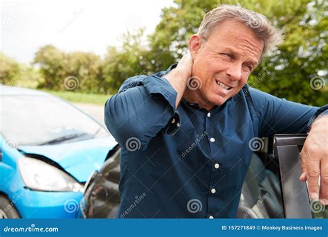 Male Motorist With Whiplash Injury In Car Crash Getting Out Of Vehicle
