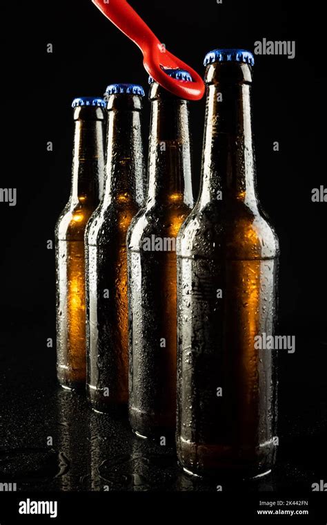 Image Of Red Bottle Opener And Four Beer Bottles With Blue Crown Caps