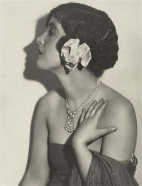 An Old Photo Of A Woman With A Flower In Her Hair