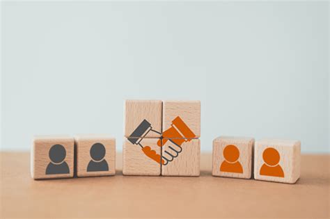 사업 계약 나무 큐브 블록에 손을 흔드는 아이콘과 비즈니스 거래 및 계약 개념에 대한 흐릿한 인간 아이콘 파트너와 최고의 관계의