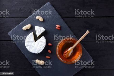 카망베르와 검은색 꿀 슬레이트 보드 금형과 땅콩에 부드러운 치즈 치즈와 견과류 돌 보드에 공간 복사 0명에 대한 스톡 사진 및