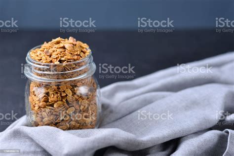 견과류 딸기 초콜릿을 어두운 콘크리트 배경에 유리 항아리에 곁들인 바삭바삭한 꿀 수제 그래놀라 아침 식사에 건강한 비건 간식