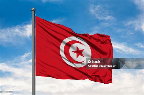 青空白い曇り風になびかせてチュニジアの旗チュニジアの旗 アイデンティティーのストックフォトや画像を多数ご用意 アイデンティティー