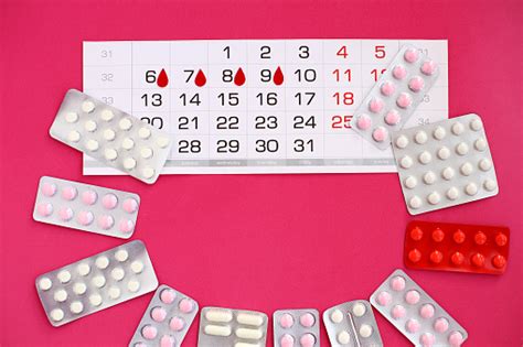 밝은 분홍색 배경에 여성의 고통에 대한 종이 혈액 방울과 흰색 분홍색과 빨간색 알약 달력 생리 주기의 일의 표시 0명에 대한