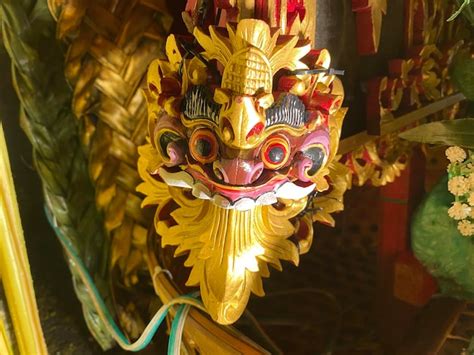 Premium Photo A Gold And Red Dragon Mask Hangs From A Wooden Boat