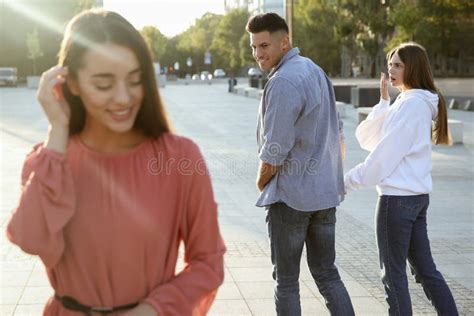 Disloyal Man Looking At Another Woman While Walking With His Girlfriend