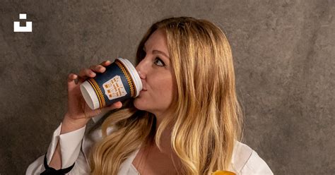 흰색 긴 소매 셔츠를 입은 여자는 갈색과 흰색 라벨이 붙은 캔을 들고 있다 사진 Unsplash의 무료 사람 이미지