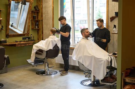 High Qualified Barbers Using Trimmer And Professional Scissors To Cut