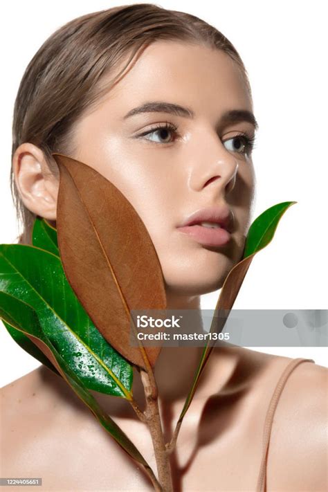 청소년 흰색 배경 위에 그녀의 얼굴에 녹색 잎과 아름다운 젊은 여자의 닫습니다 화장품 메이크업 내츄럴 에코 트리트먼트 스킨 케어