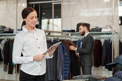 Premium Photo Pretty Brunette Shop Assistant Looking At Tablet